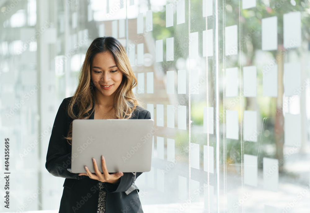 Cheerful young woman holding laptop computer. Pretty lady model with ...