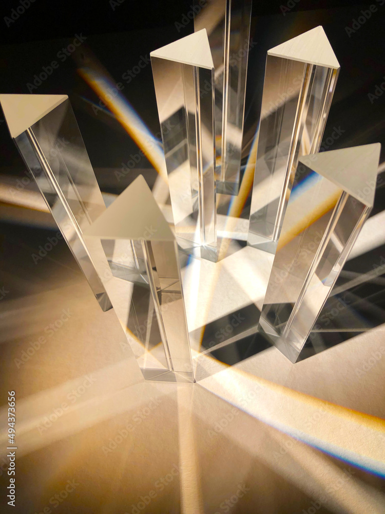 Close up of group of crystal clear triangular glass prisms refracting ...
