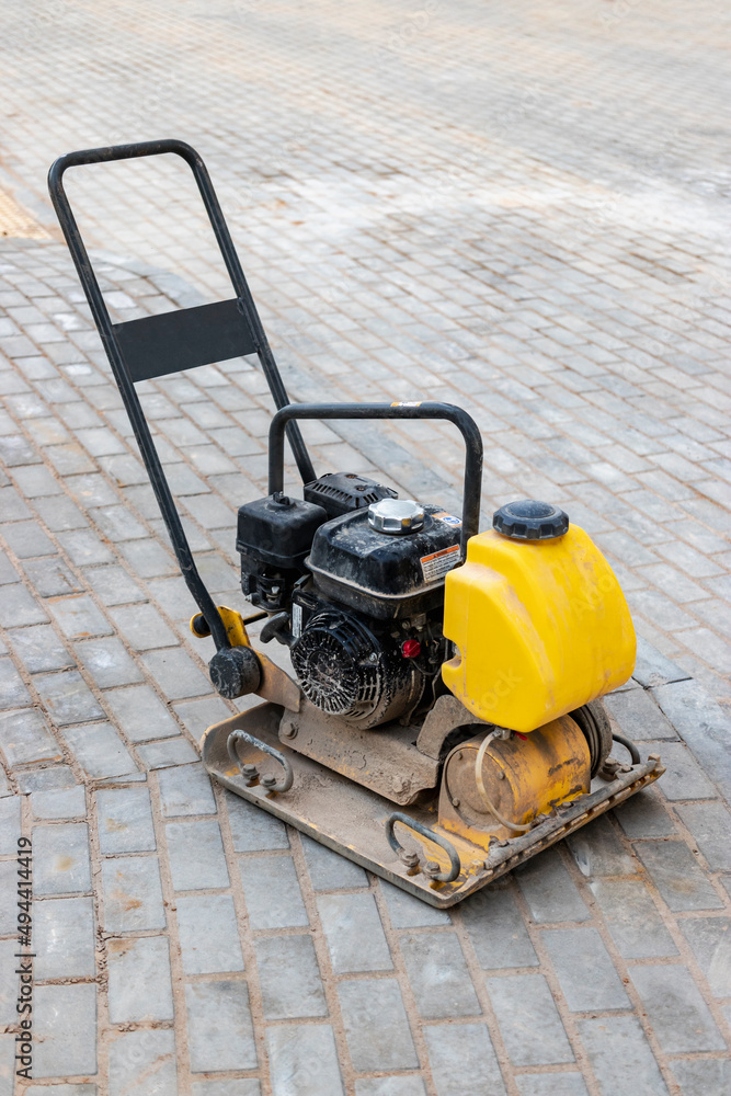 Vibratory rammer with vibrating plate on a construction site ...