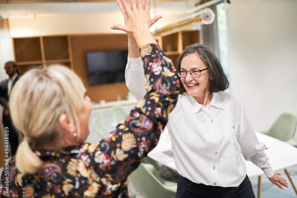 Two business women in the conference room giving a high five Stock ...