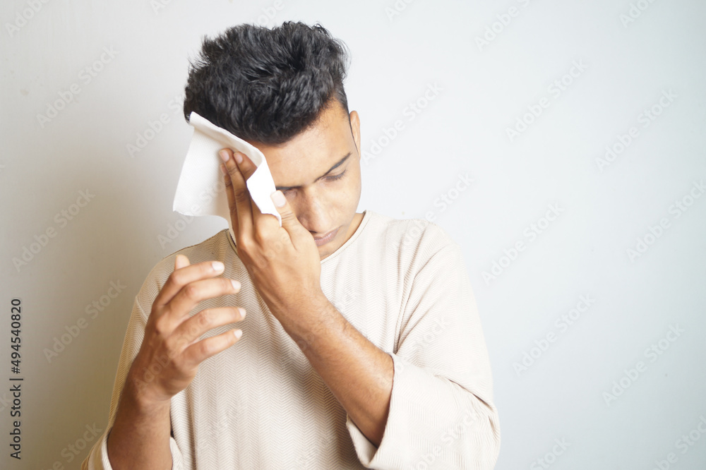 Young man wiping the sweat off his forehead with a napkin Stock Photo ...