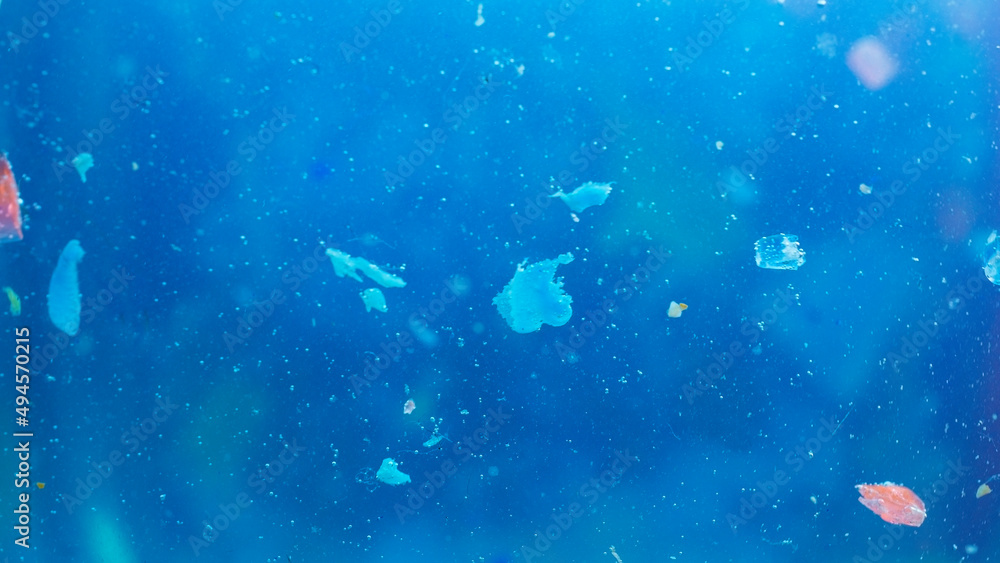 Microplastics on the surface of a polluted water. Concept of global ...