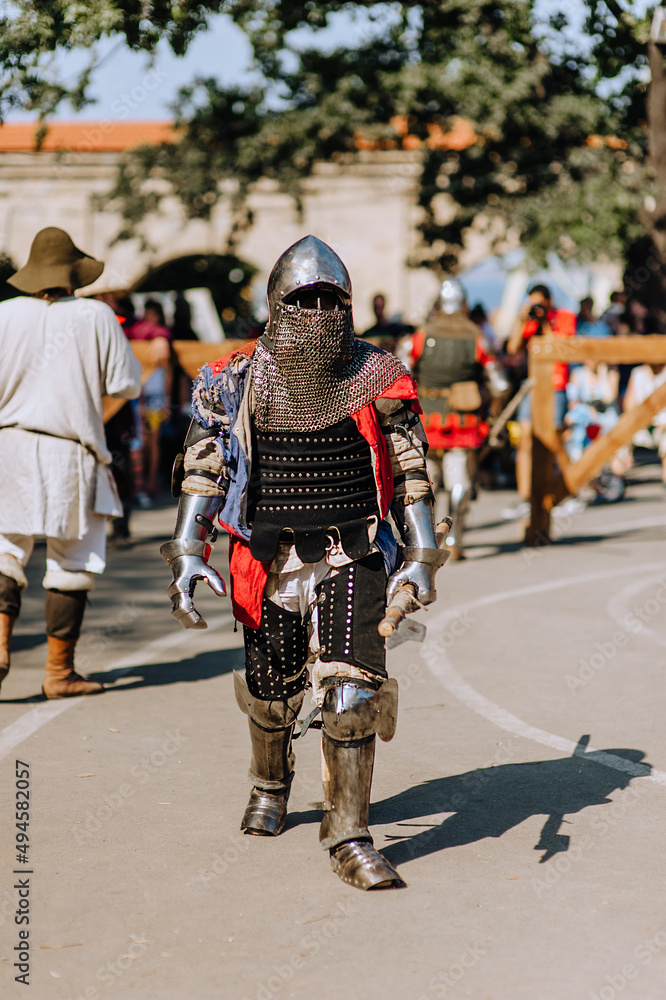 A strong knight, a warrior stands walking across the battlefield ...