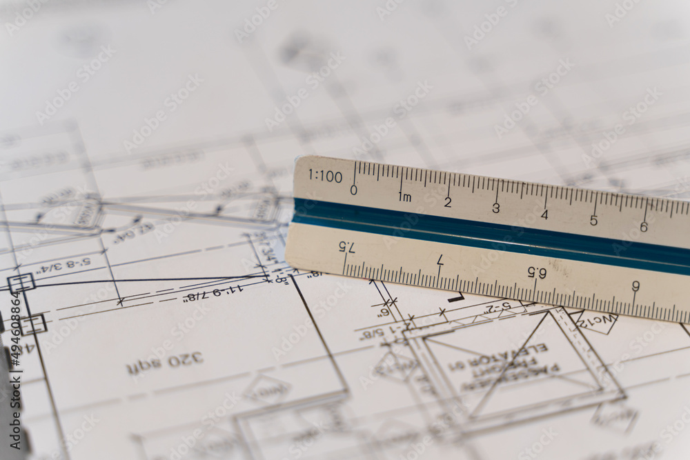 Architectural Scale Ruler with paper blueprints plans for new building ...