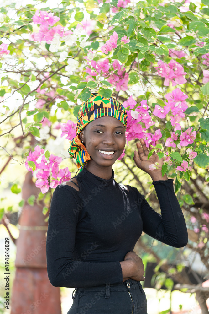 Gorgeous African girl under a natural arch of lush pink and white ...