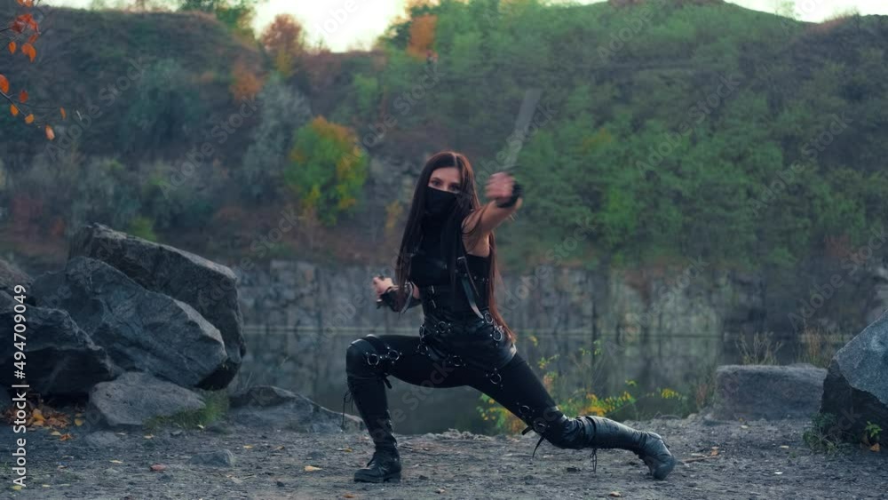 active fantasy woman warrior assassin holds with two blade daggers in ...