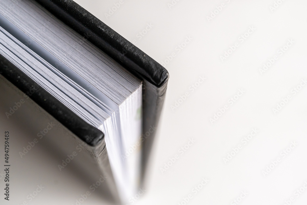 detalle de esquina de libreta negra cerrada con hojas blancas sobre ...