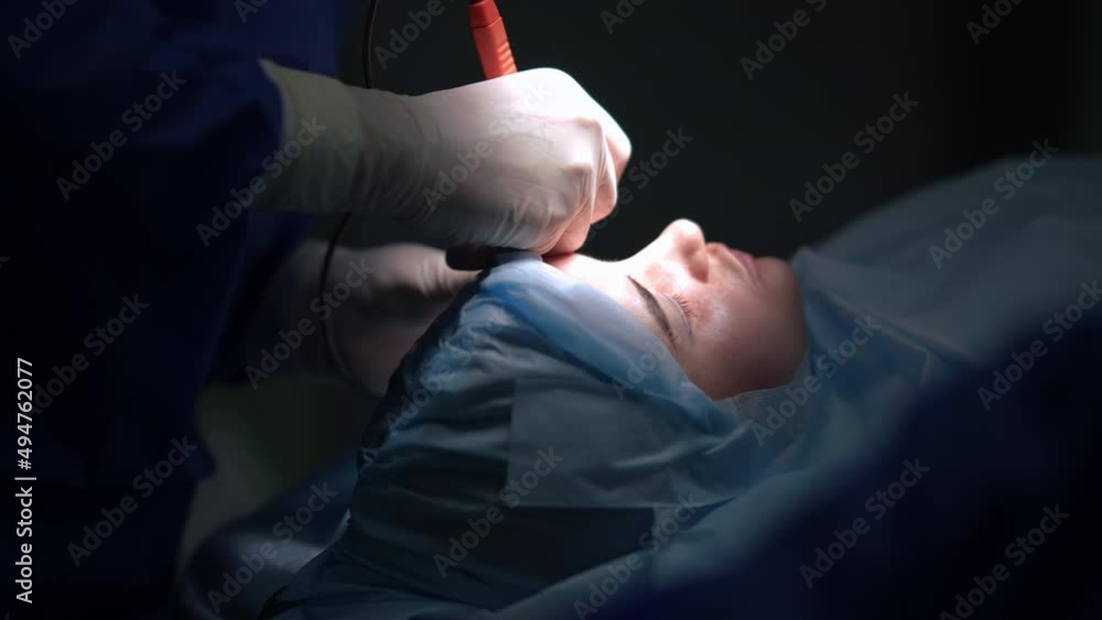 Side view portrait of woman lying on surgery bed as unrecognizable ...