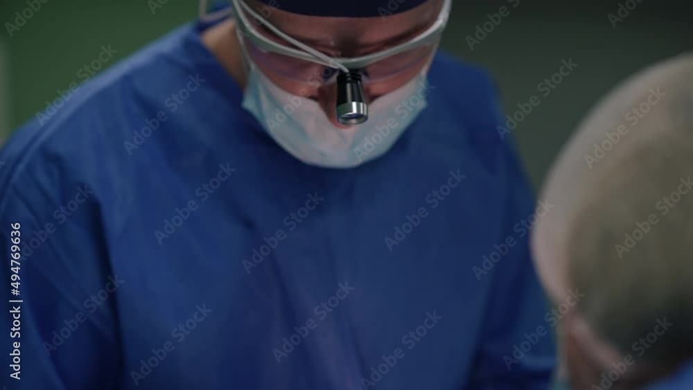 Portrait of Caucasian expert surgeon stitching dissection with cautery ...