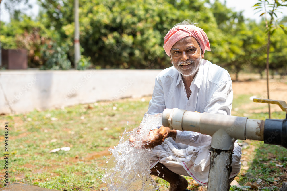 Happy Indian farmer after seeing water on borewell pipe at farmland ...