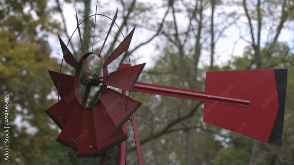 Windmill spinning showing wind direction with fall foliage in the ...