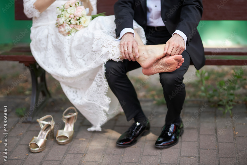 the groom gives the bride a foot massage. Close up a bride putting her ...