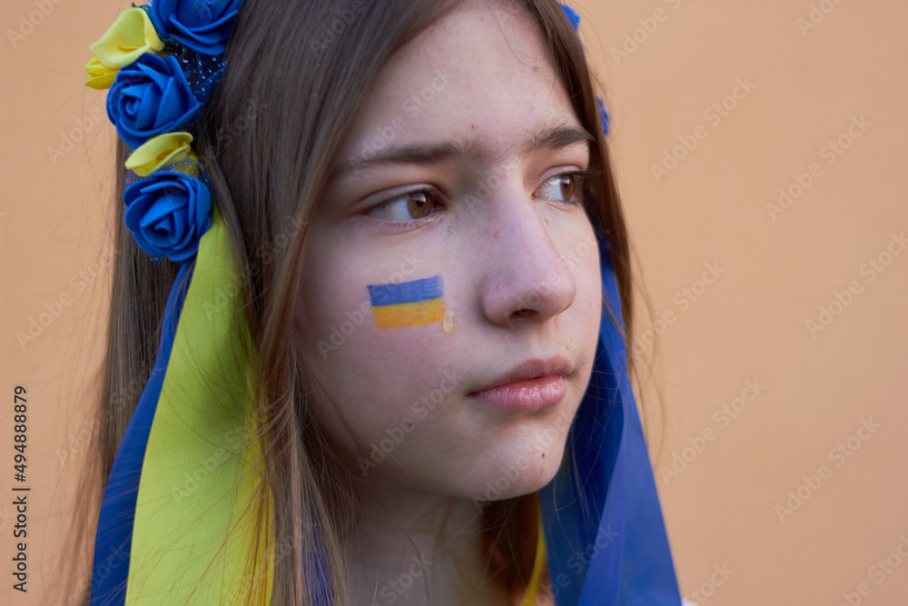 A sad Ukrainian woman in a blue-yellow flower wreath, a crying child ...