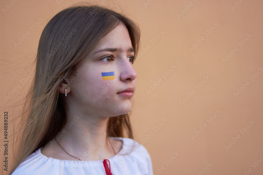 Foto de Sad little Ukrainian girl with the flag of Ukraine on her face ...