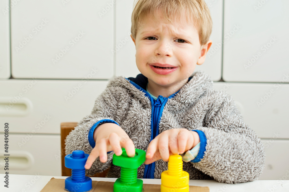 Shapes, colors and fine motor skills. toddler turns the nut on the bolt ...