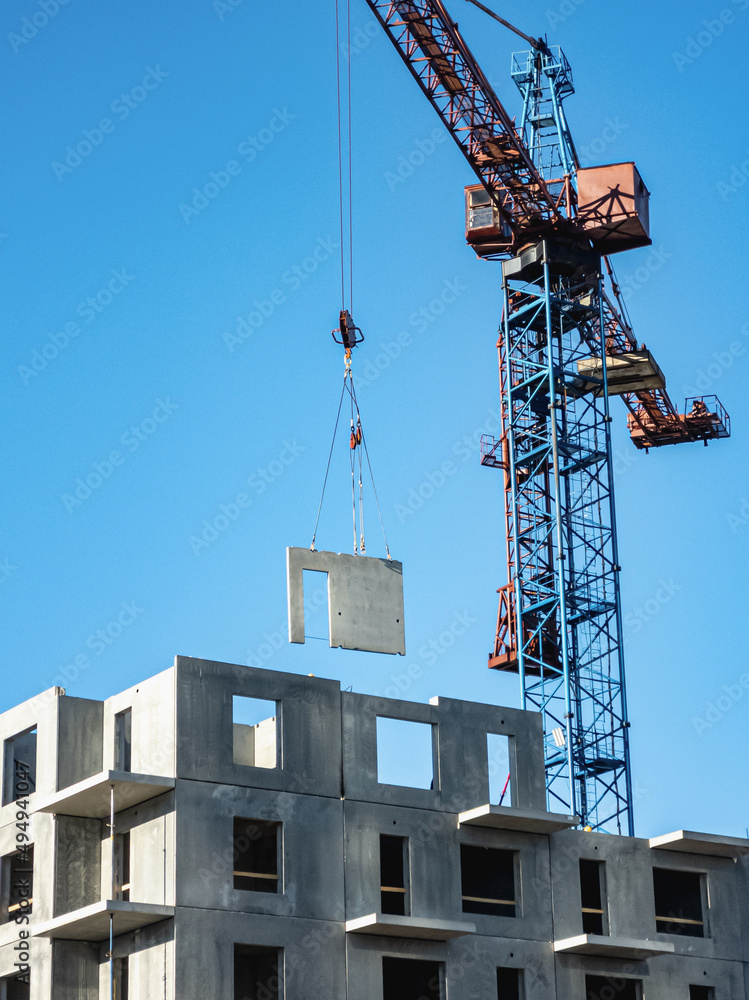 Construction of panel high-rise buildings. Tower crane delivers a ...