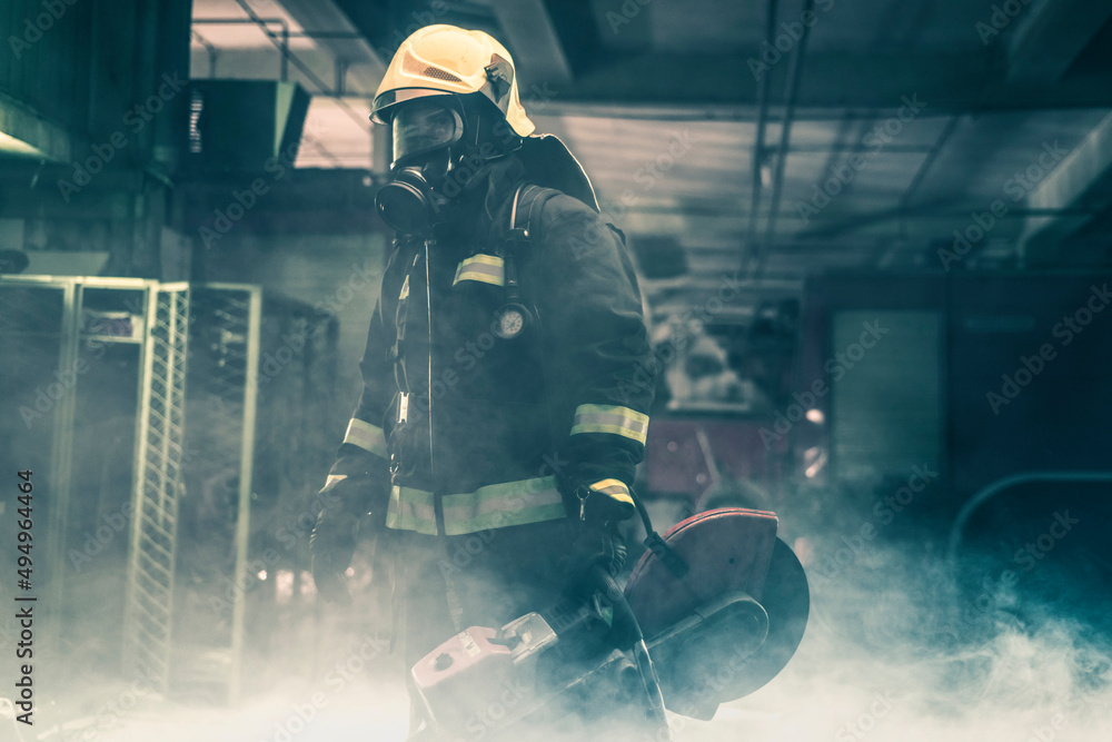 Portrait of a firefighter wearing full protective equipment posing with ...