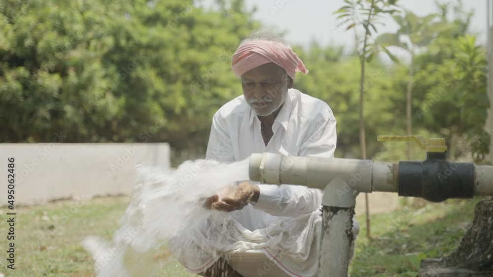 Happy Indian farmer after seeing water on borewell pipe at farmland ...
