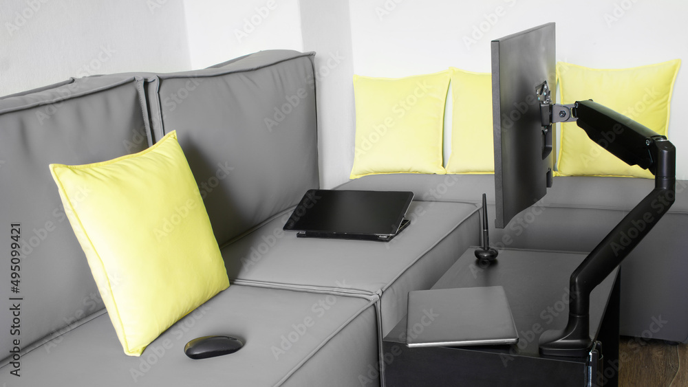 Modern computer monitor is mounted on a small table with a gas-lift ...