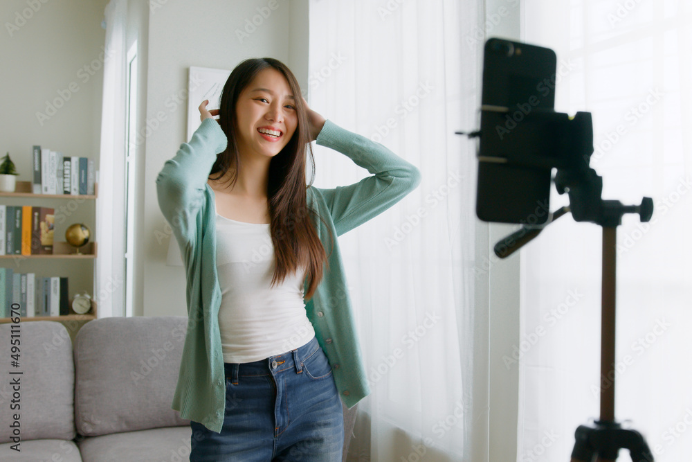 Asian young woman created her dancing video by smartphone camera. To ...