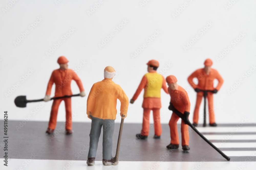 Miniature figurines of men at work with an old man looking at their ...