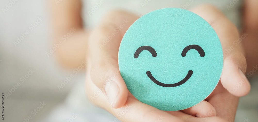 Hands holding green happy smile face paper cut, good feedback rating ...