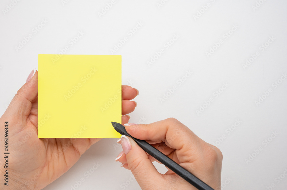Hand written notes black pencil on yellow sticker. white table ...