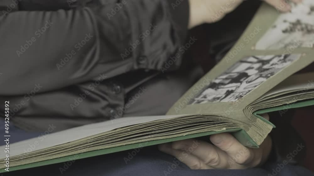Human hand browsing old photo album pages. Woman is looking photo her ...