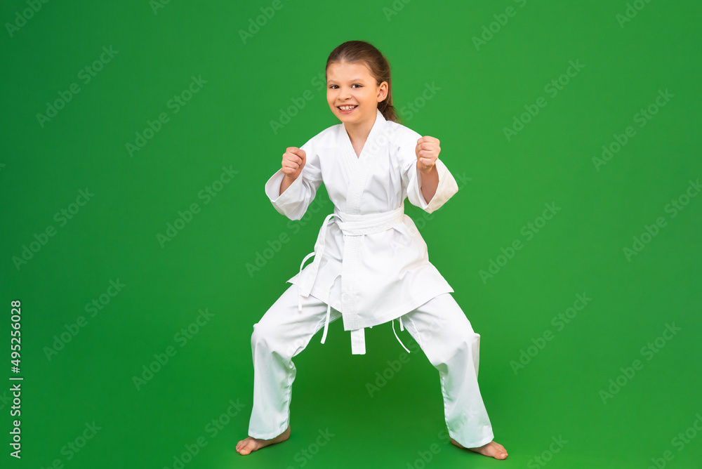 A child in a white kimono, martial arts from an early age, children's discipline, a karate girl ...
