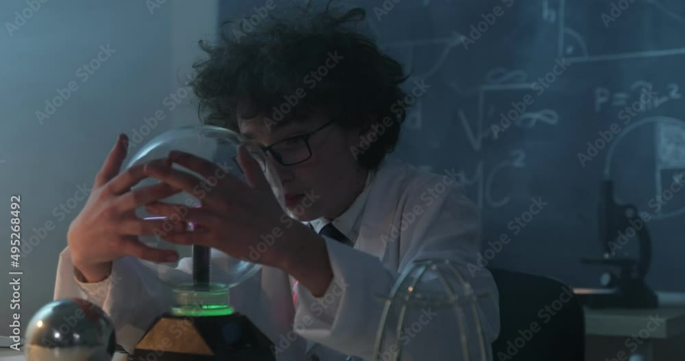 Schoolboy experimenting in physics class. Young student doing physics ...