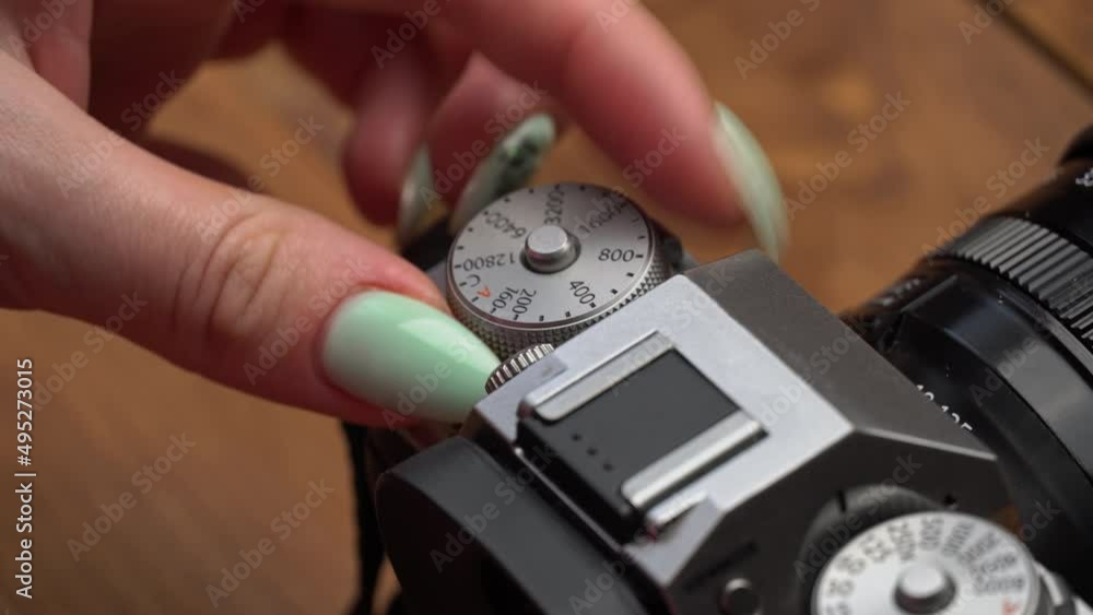 Girl's hands are spinning the iso wheel on a vintage camera close-up ...
