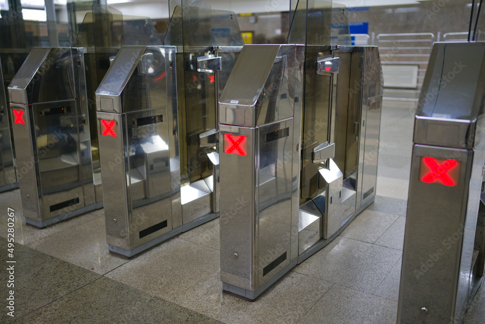 Automatic turnstiles with a burning red crosshair. The passage is ...