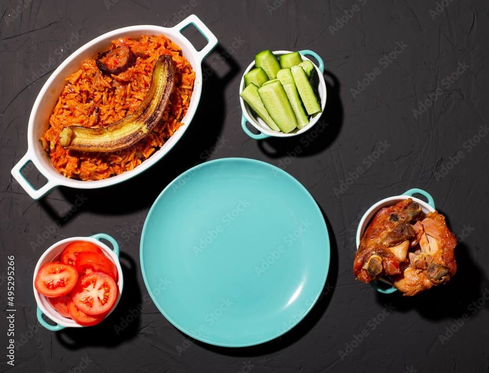 Jollof rice with fried banana, baked chicken. Rice with tomatoes ...