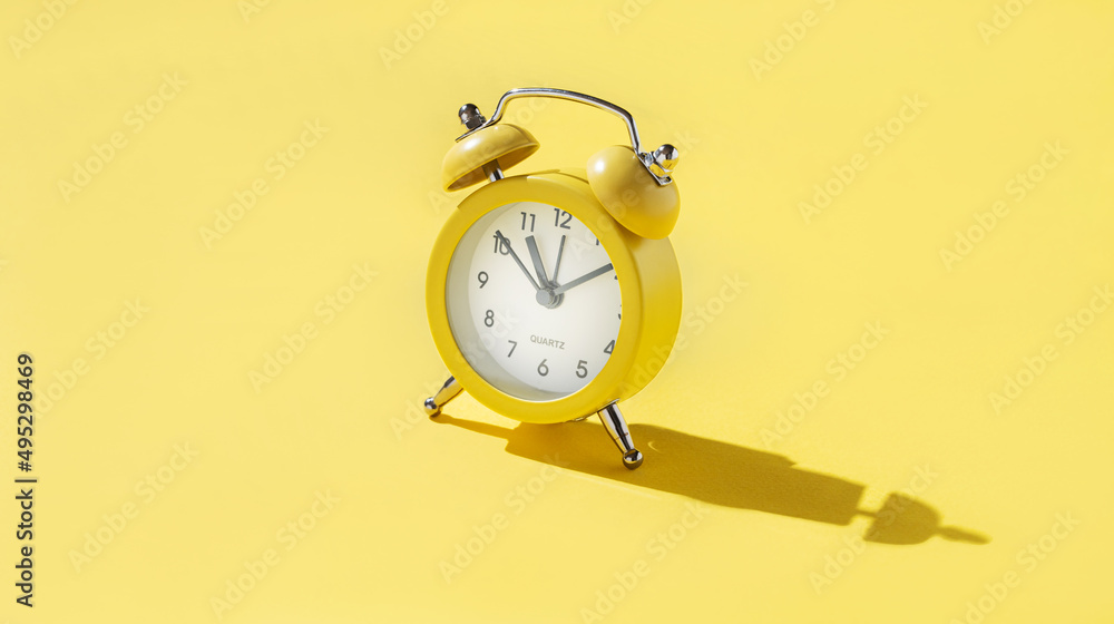 One small alarm clock with a double bell made of yellow metal on a ...