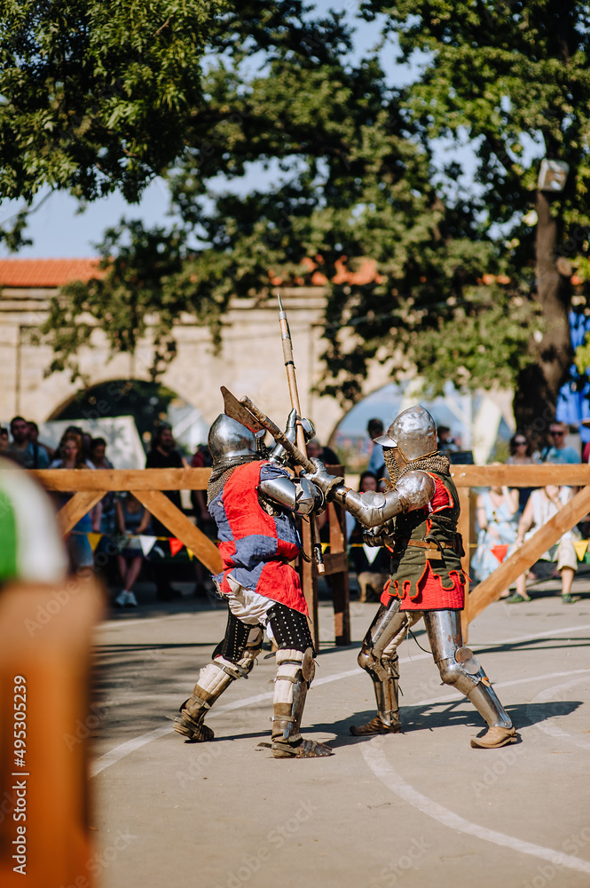 Two knights, warriors are fighting on the battlefield in armor with an ...