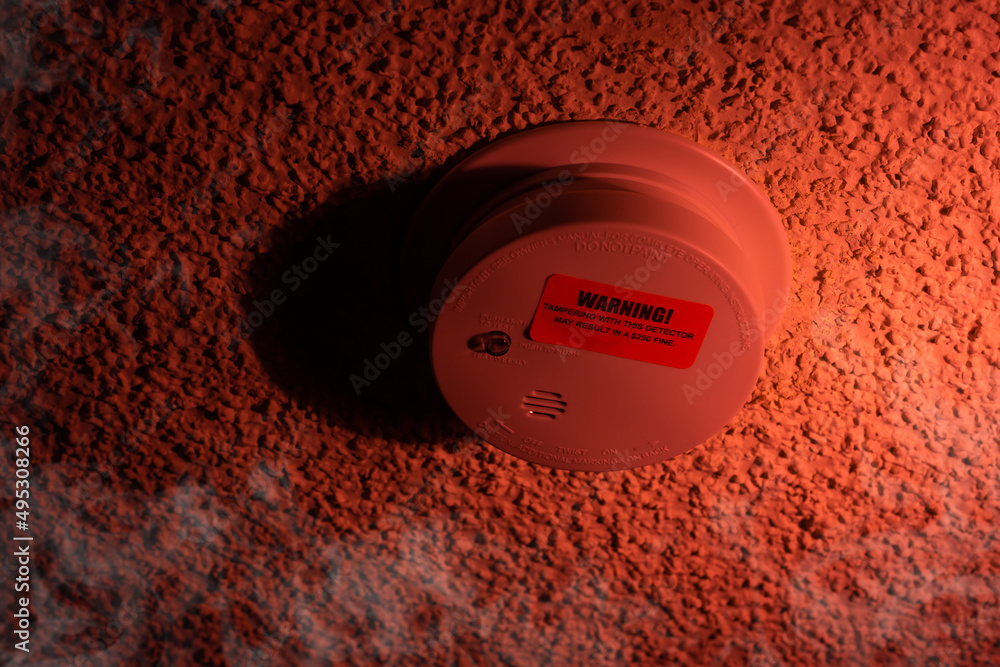 Fire alarm button on a bright orange background and smoke. There are no ...