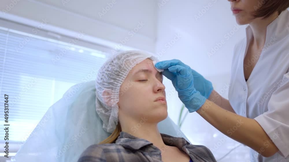 young woman injected with botulin into skin of face. rejuvenating ...