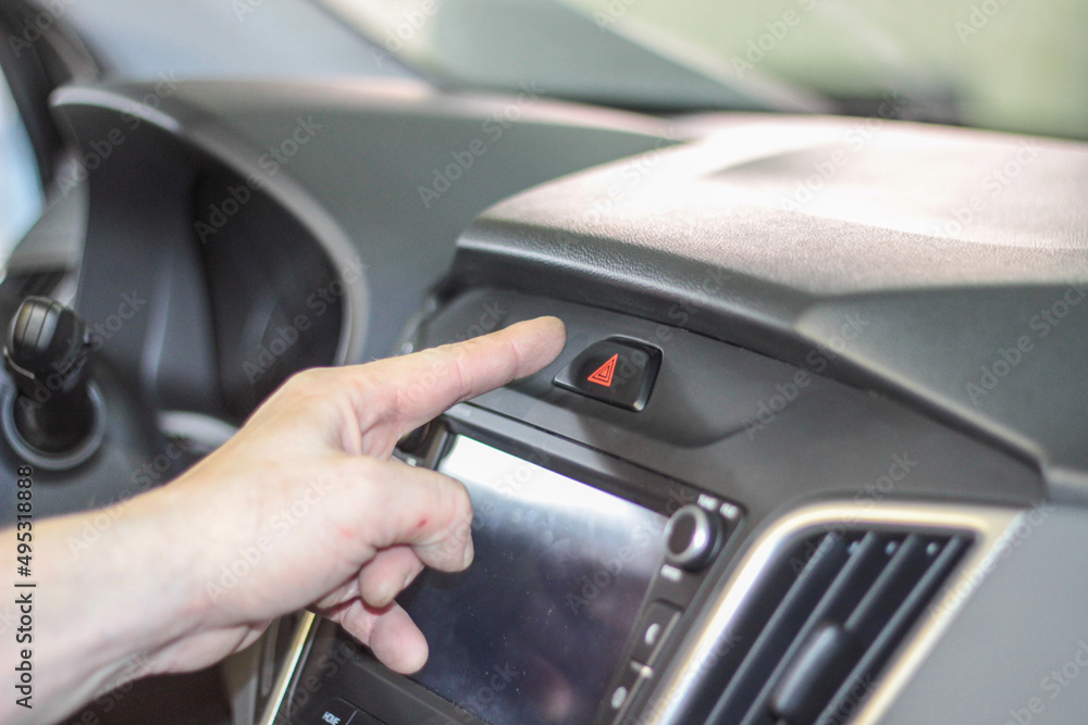 Closeup of man's hand pressing emergency stop button in car. using ...