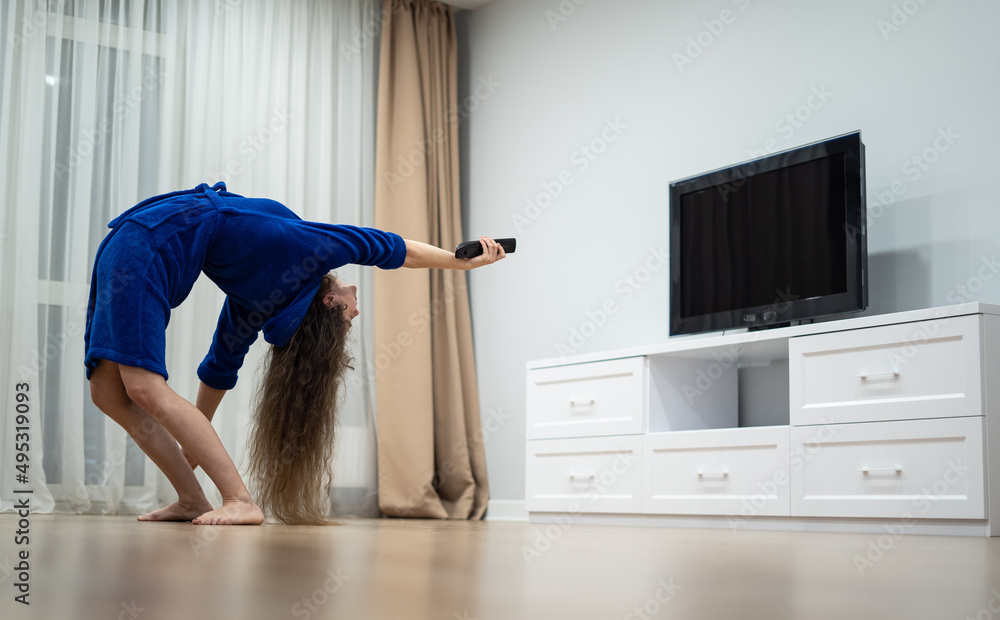 A creepy, devil-possessed woman like a zombie watching at tv screen ...