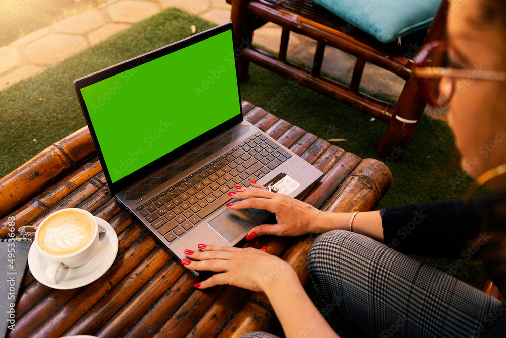 Latin business woman with curly hair and glasses checks her computer ...