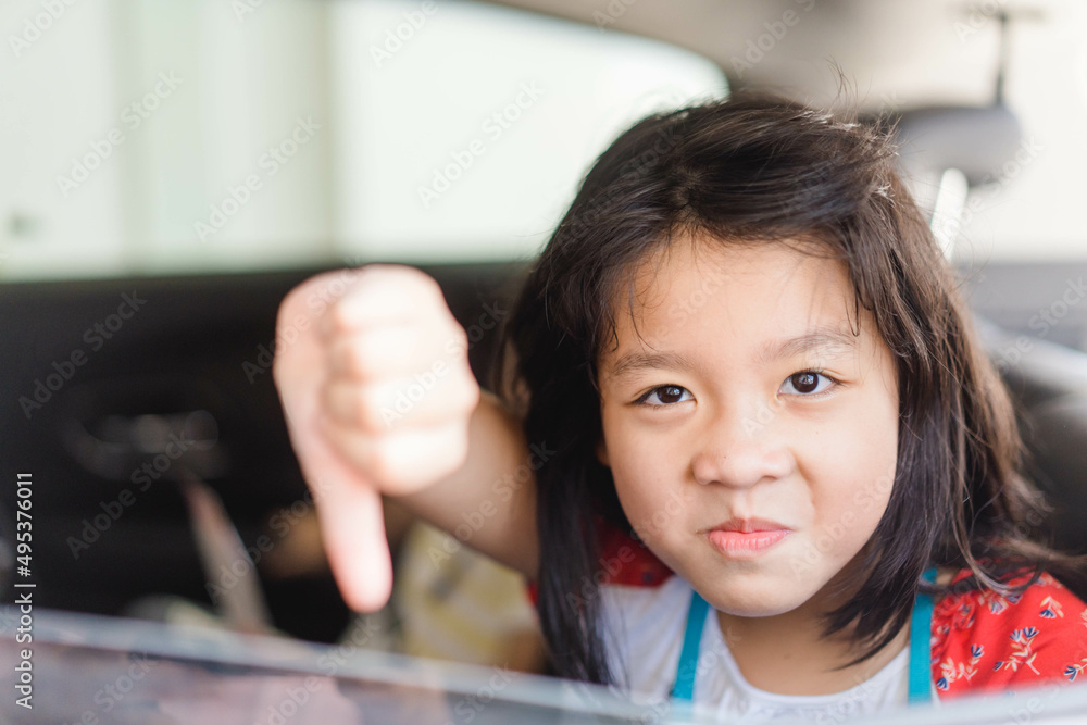 Asian kid tween girl thumb down with smile on seat.Family Riding Car Traveling Automobile. Asian ...
