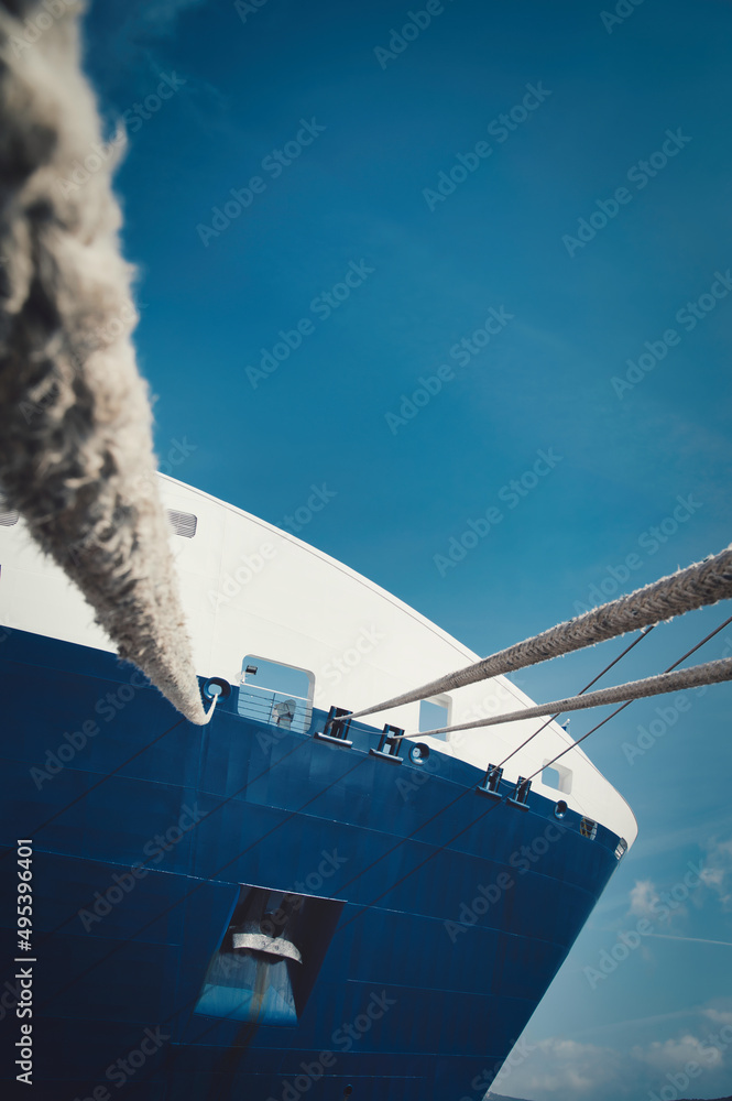 cruise ship docked at the port with ropes on sky background, mooring a ...
