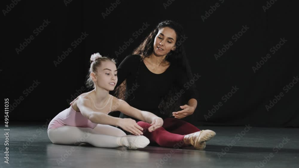 Adult woman coach dancer teacher sitting on floor with girl teenager ...