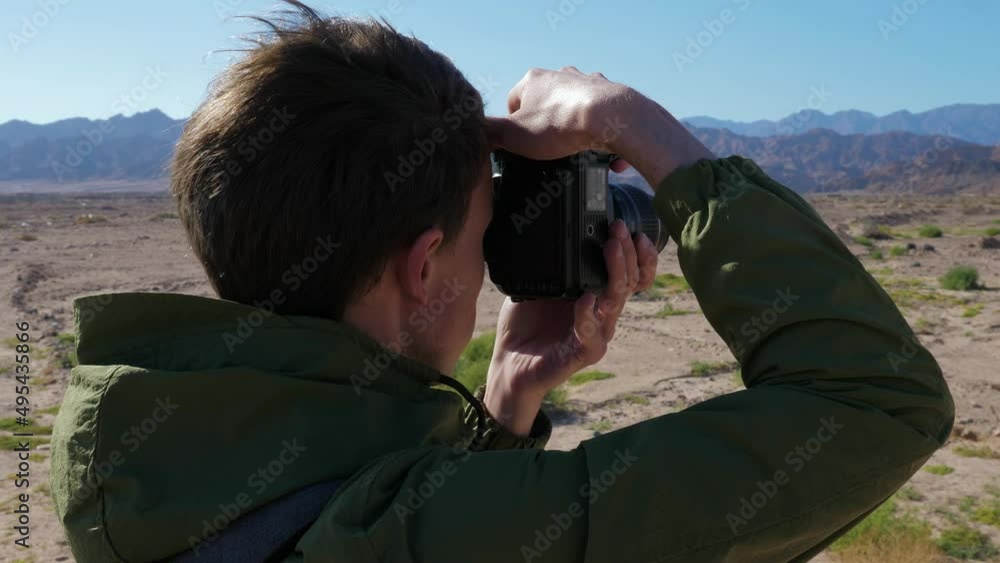 Photographer takes pictures of mountain landscape. Male tourist ...