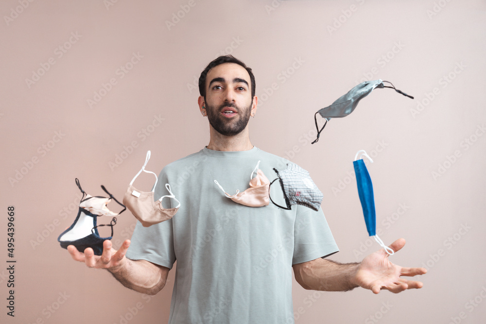 Excited man throwing facemasks against pink background Stock Photo ...
