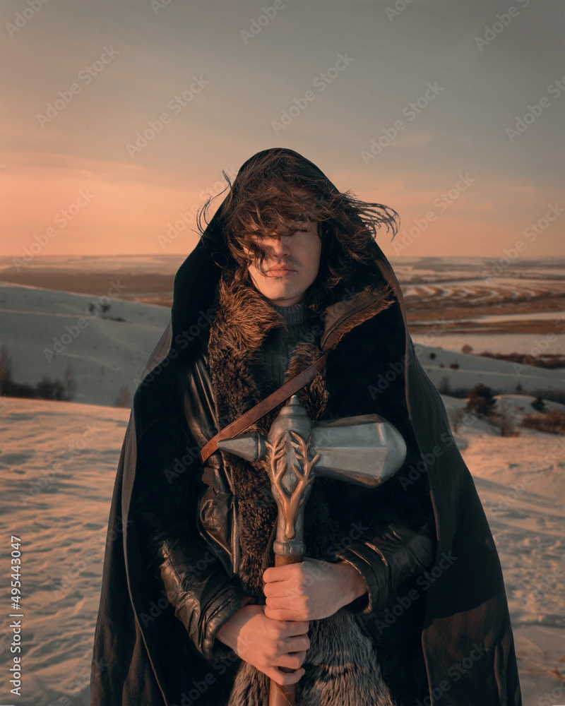 Medieval warrior against the backdrop of a sunset and a snowy field ...