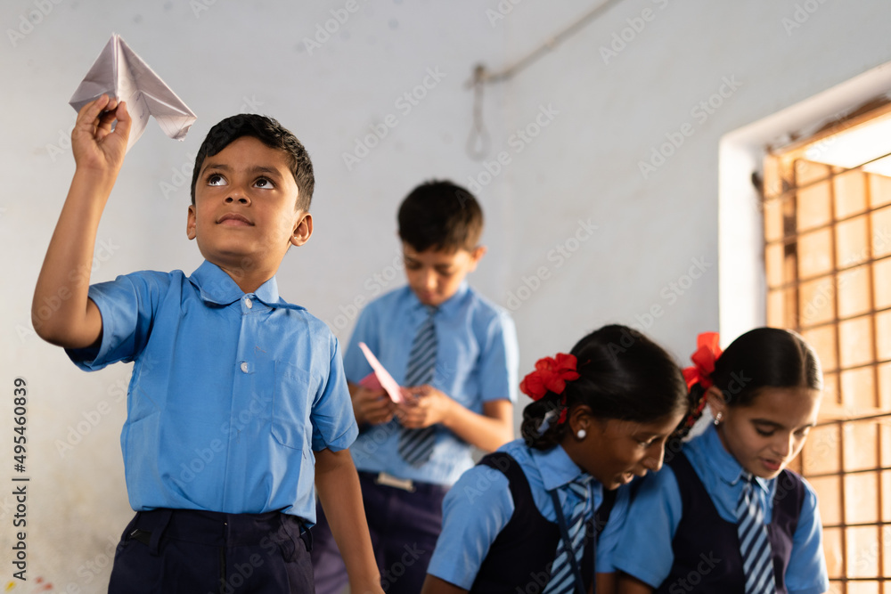 teenage kid playing by throwing paper plane in classroom - concept of ...