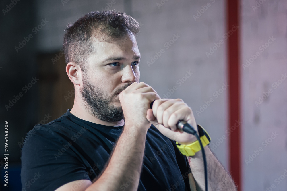 Smiling and witty stand up actor comedian on stage, talking and singing ...