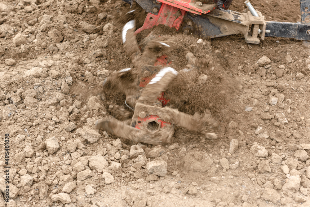 Small farm tractor plows the ground, the work of a walk-behind tractor ...