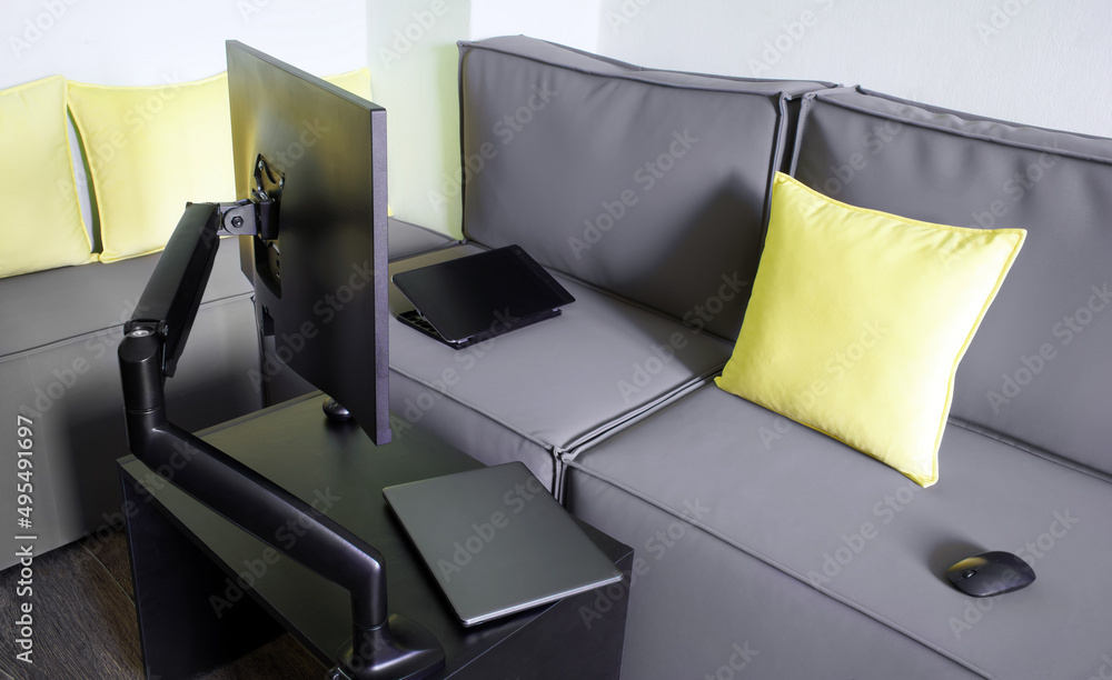 Modern computer monitor or monoblock is mounted on small table using ...